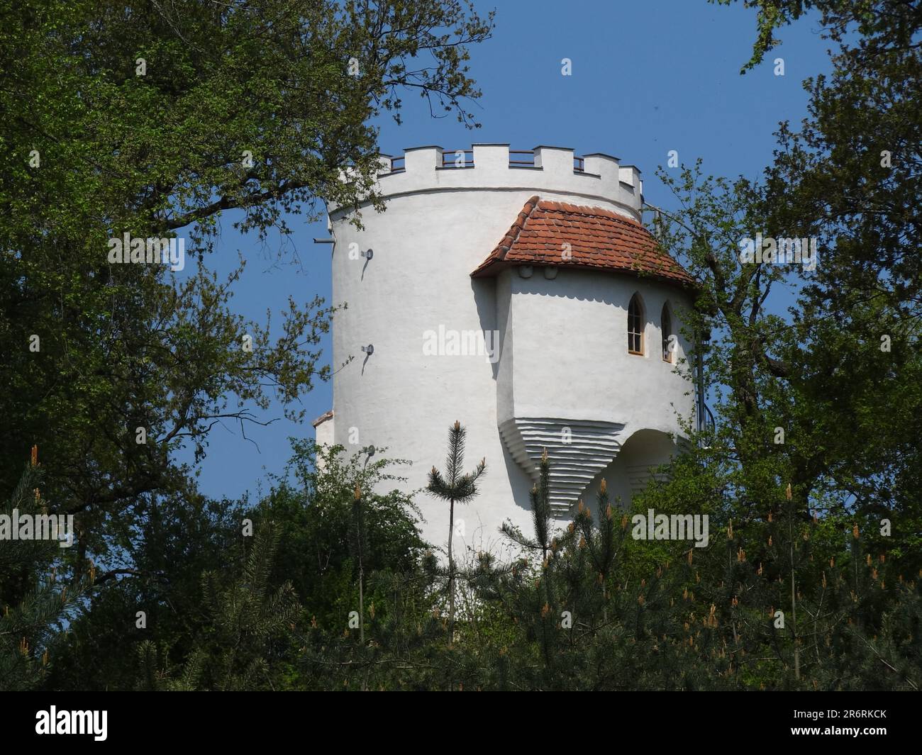 A renovated old white castle ruins with a viewing platform and a bay ...