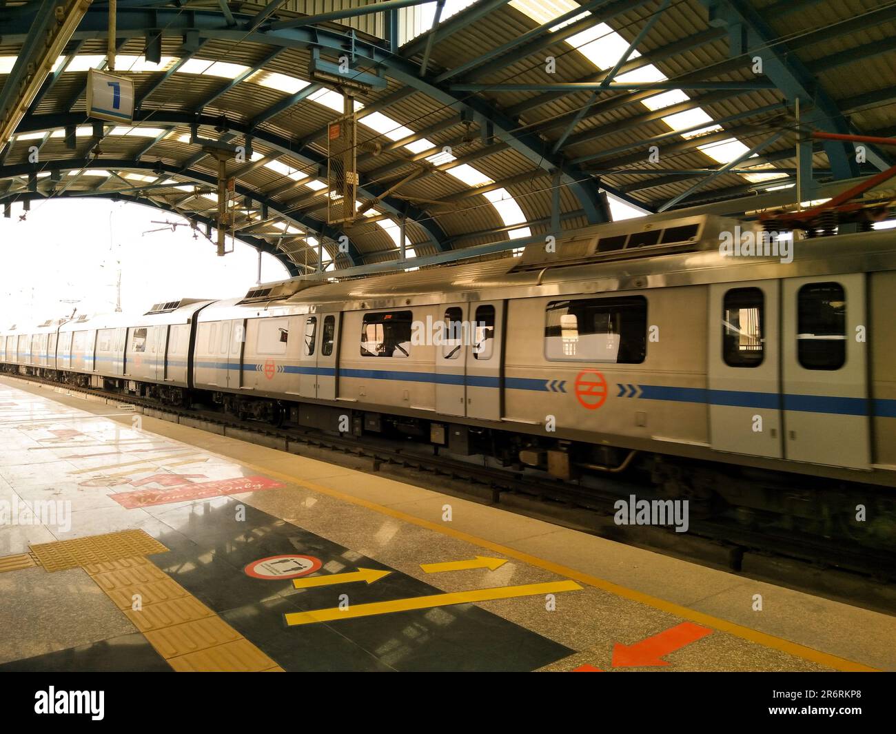 A modern train car slowly making its way along a set of railroad tracks ...