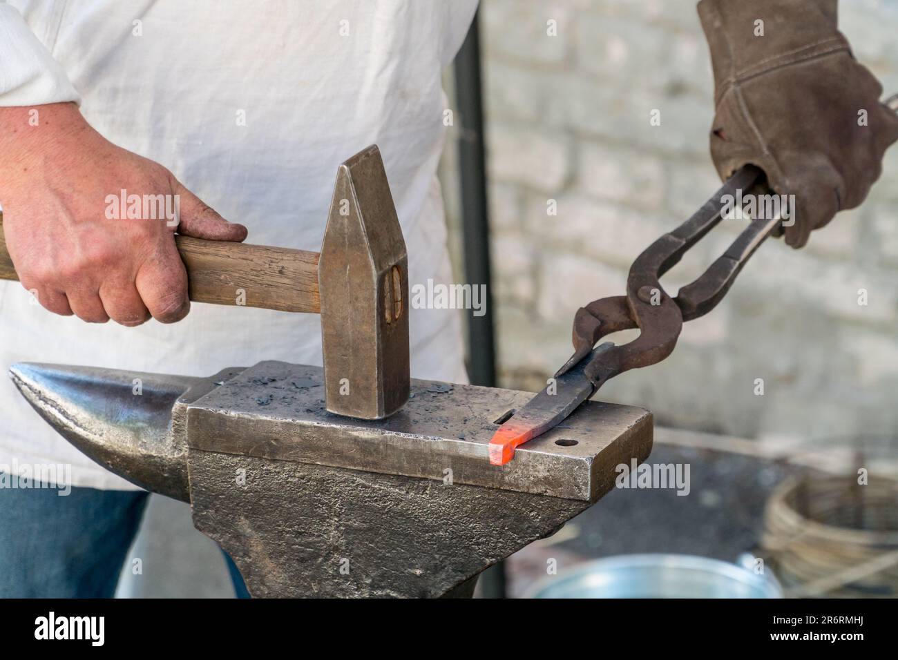 Blacksmith at work making horseshoe in Ukraine. Handmade craftmanship ...