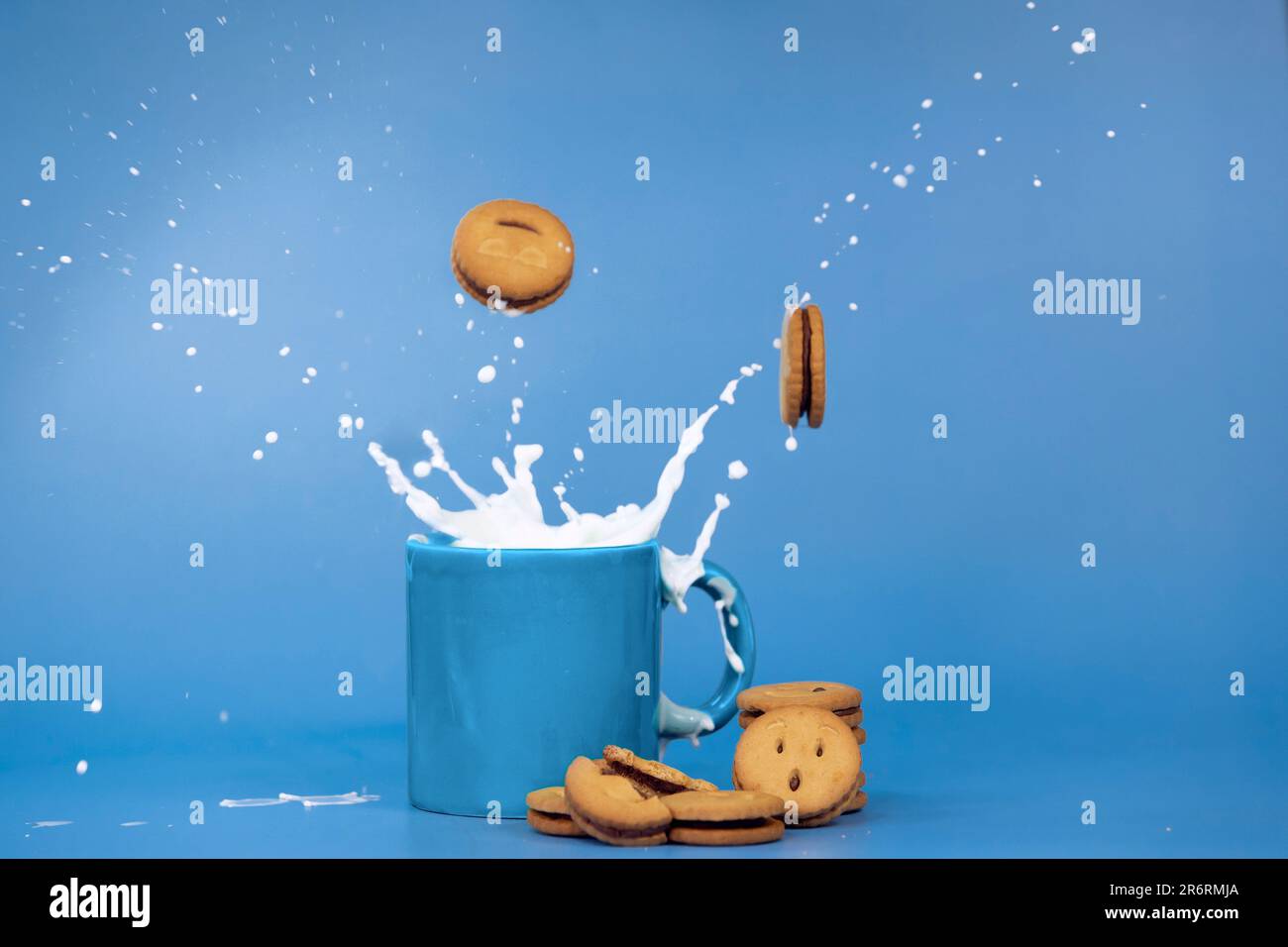 An image of an assortment of doughnuts falling into a cup of milkk ...