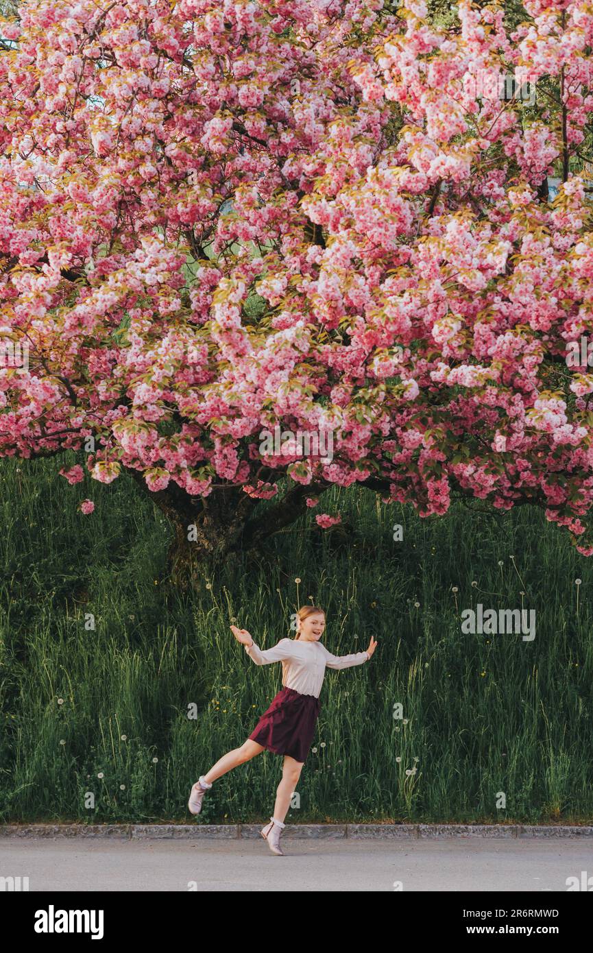 Spring image of blooming sakura. Kid girl playing with decorative ...