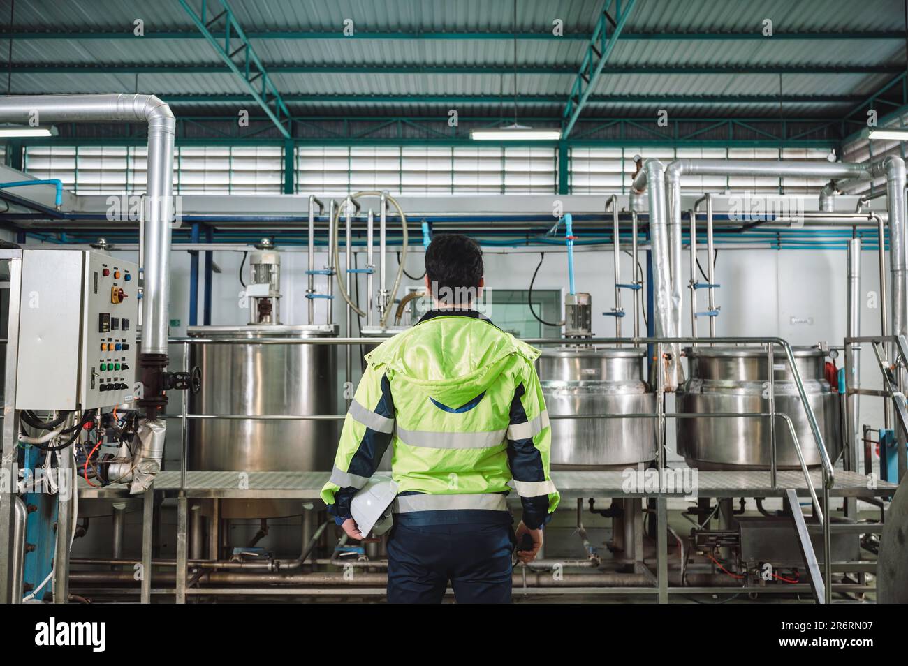 Confident caucasian technician engineer man in safety uniform standing ...
