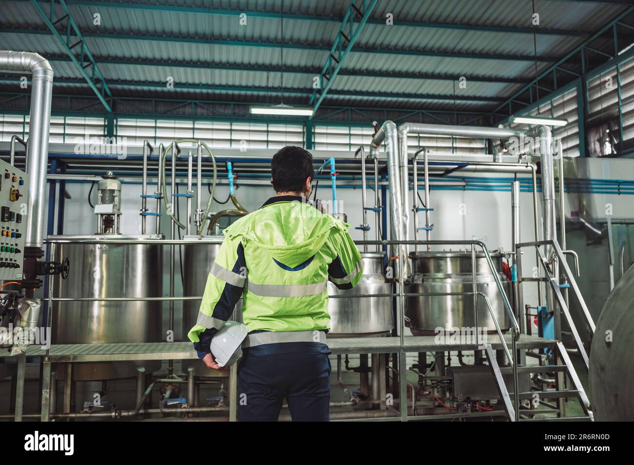 Confident caucasian technician engineer man in safety uniform standing ...