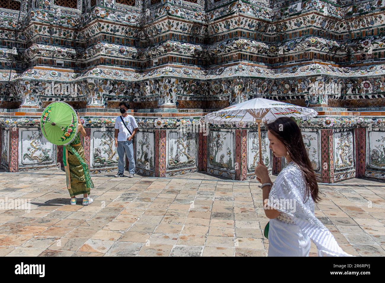 A tourist dressed in traditional Thai clothing visits Wat Arun in ...
