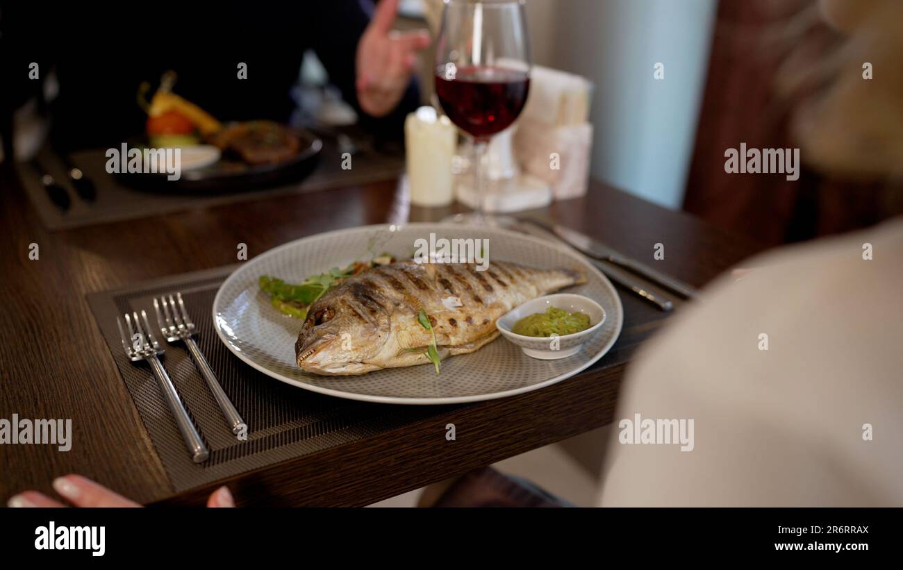 The waiter puts delicious dishes on the table. The waiter puts ...