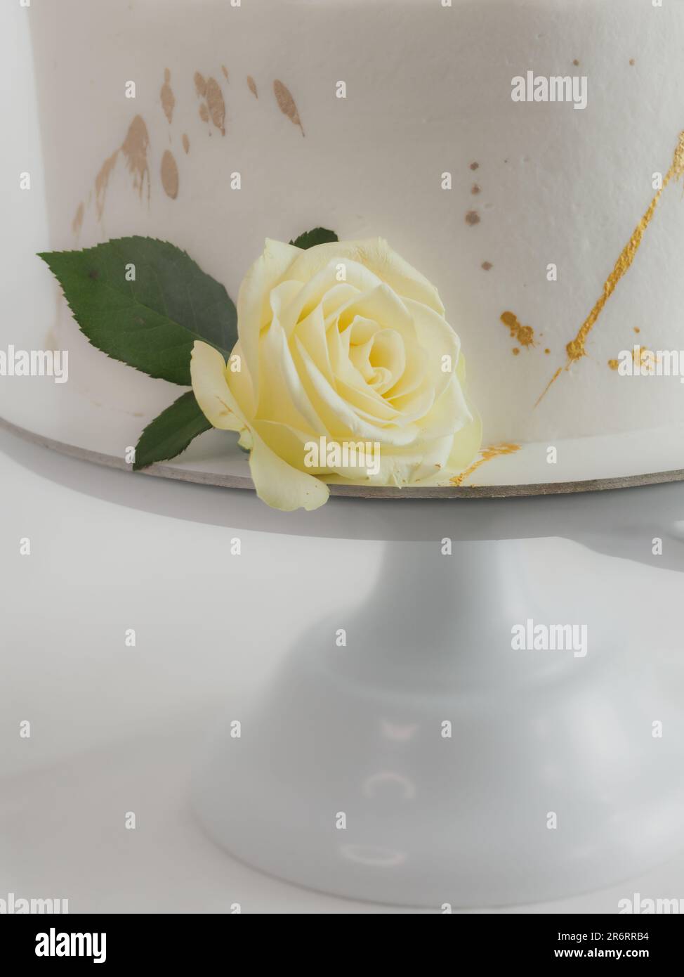 frosted tall cake with real roses and gold brush strokes of edible ...