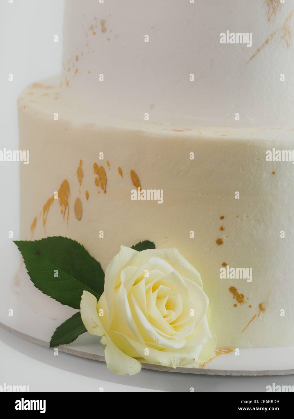 frosted tall cake with real roses and gold brush strokes of edible ...