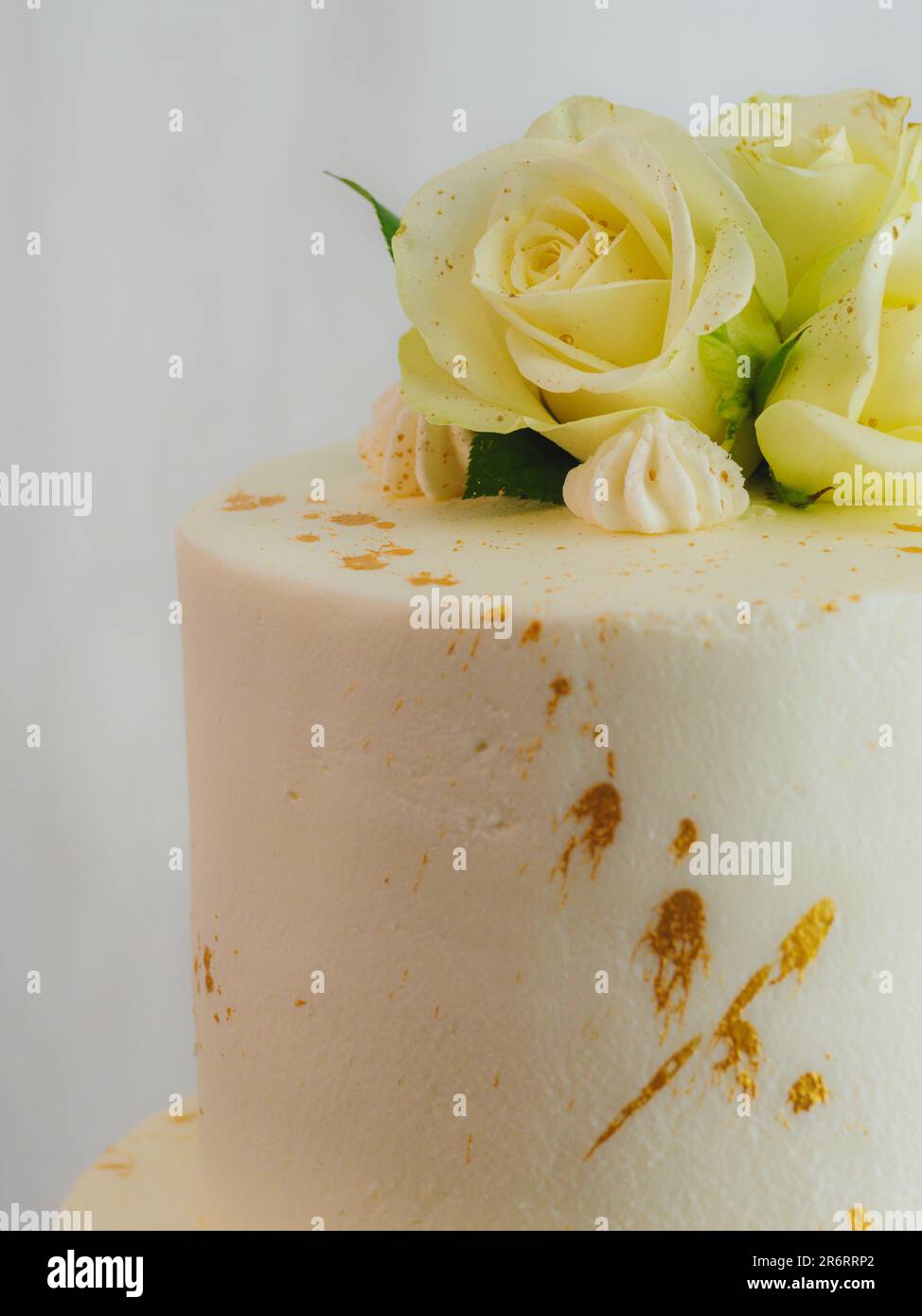 frosted tall cake with real roses and gold brush strokes of edible ...