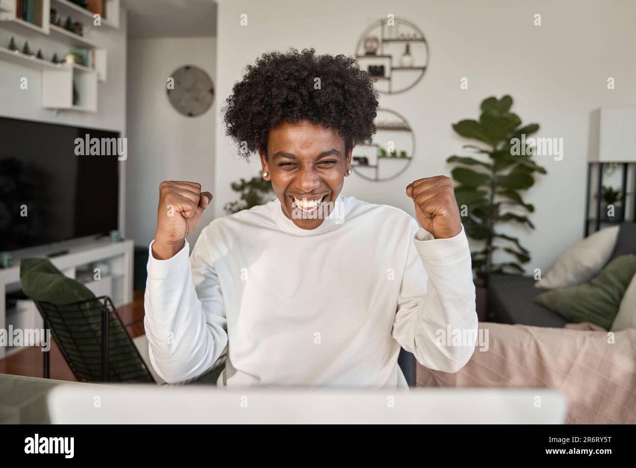 Happy African gen z student getting good news celebrating looking at ...
