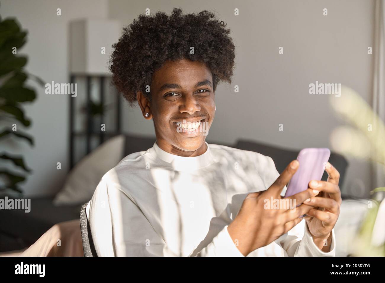 Happy gen z African American teen using mobile phone at home, portrait ...