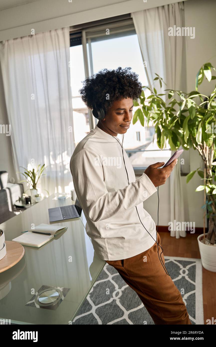 Happy cool gen z African American guy wearing headphones at home Stock ...