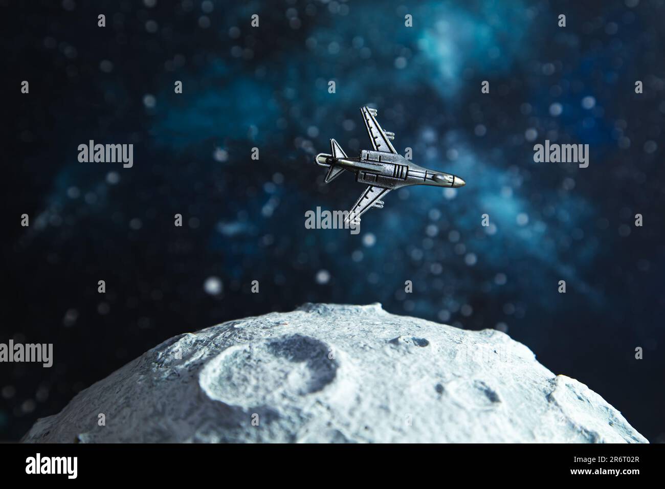 Toy plane flies near the moon, starry background. The concept of space ...