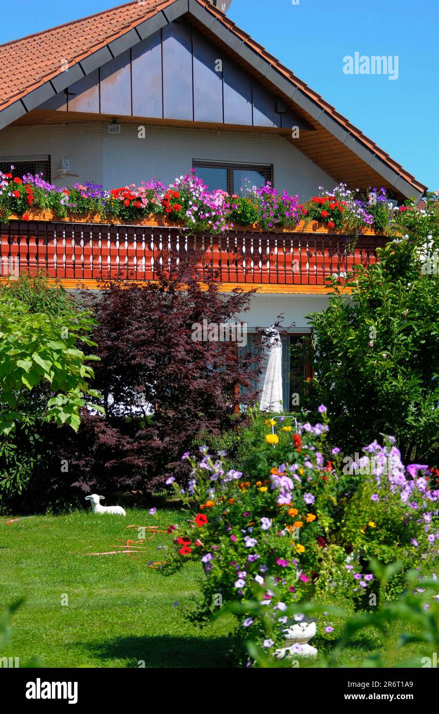 Residential house in garden, balcony with flowers, ornamental garden ...