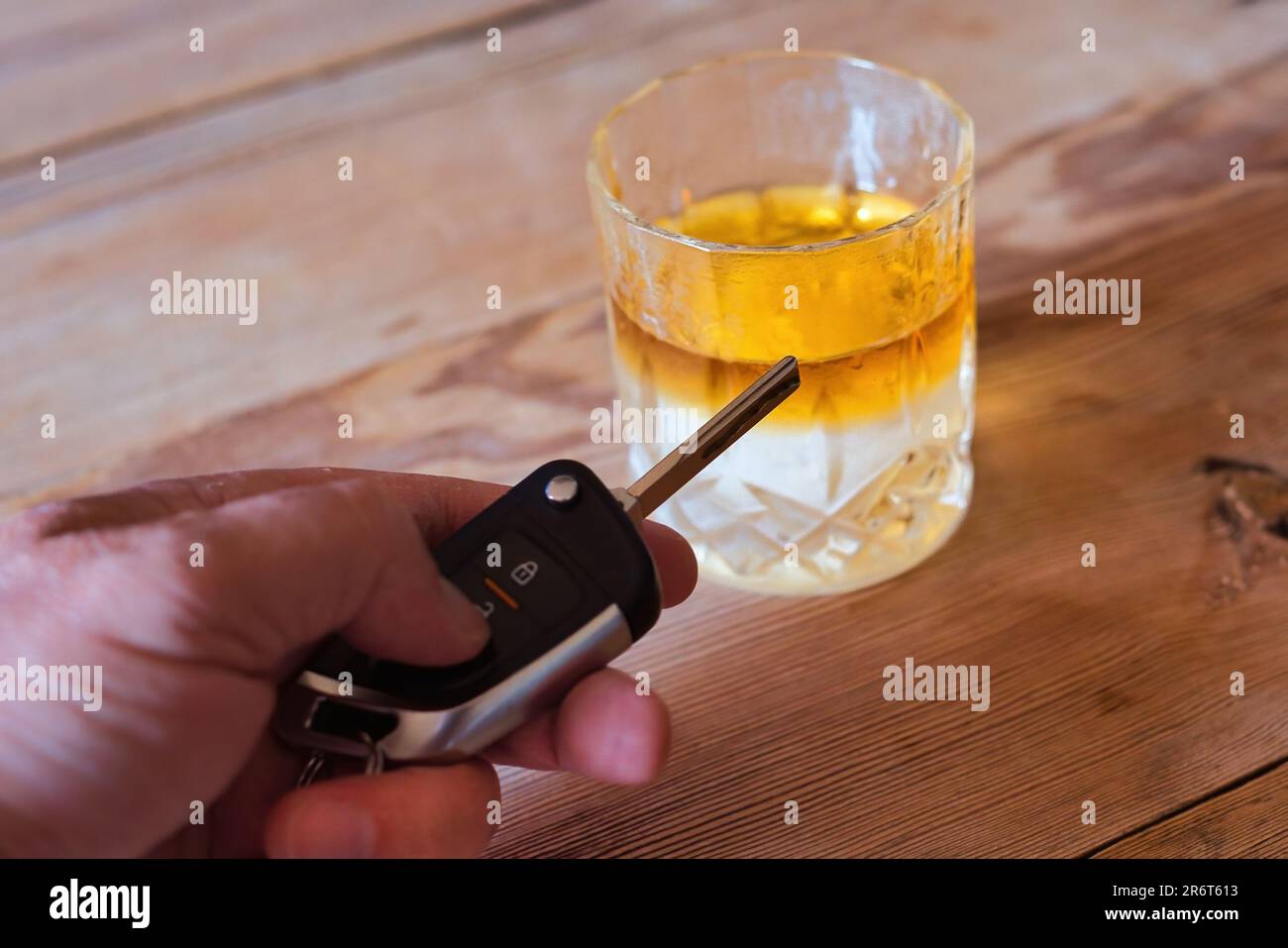 Glass with whiskey and ice and car keys on a wooden background. drunk ...