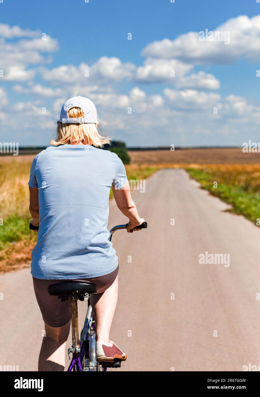 girl riding a bike on a country road. woman on a bicycle. girl riding a ...