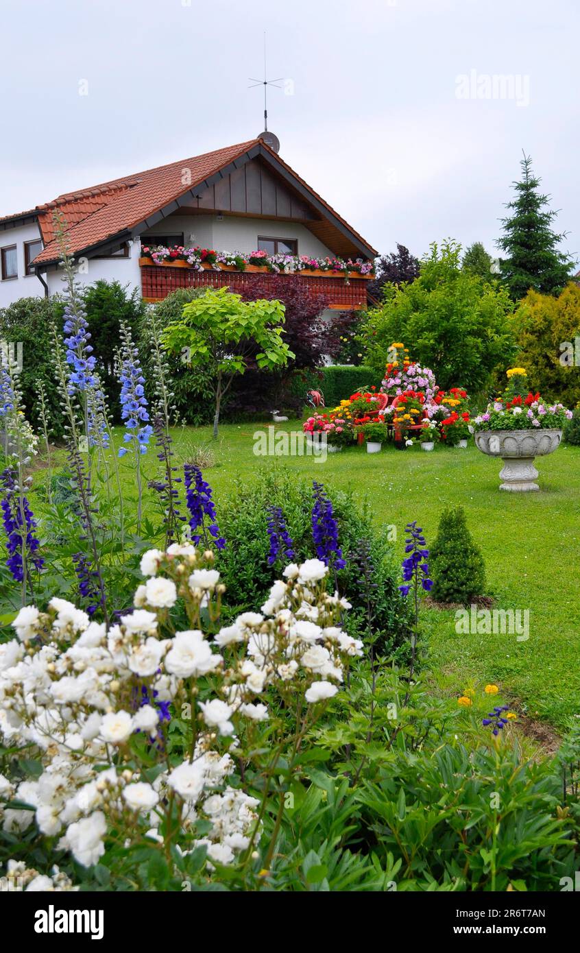 Pyramid of flowers in the garden, flowerpot with flowers, lawn, white ...