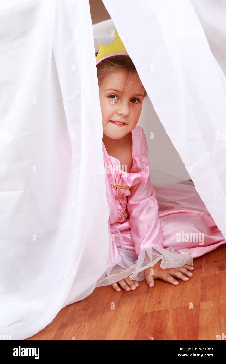 Adorable girl dressed as princess playing hide-and-seek at home Stock ...