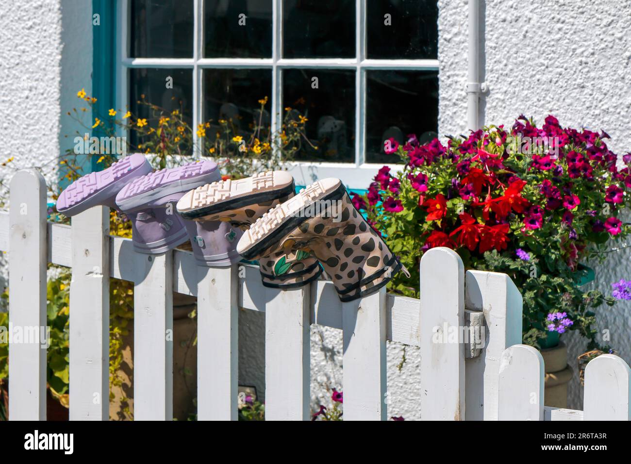 Two Pairs of Boots Placed on Fence Posts Stock Photo - Alamy