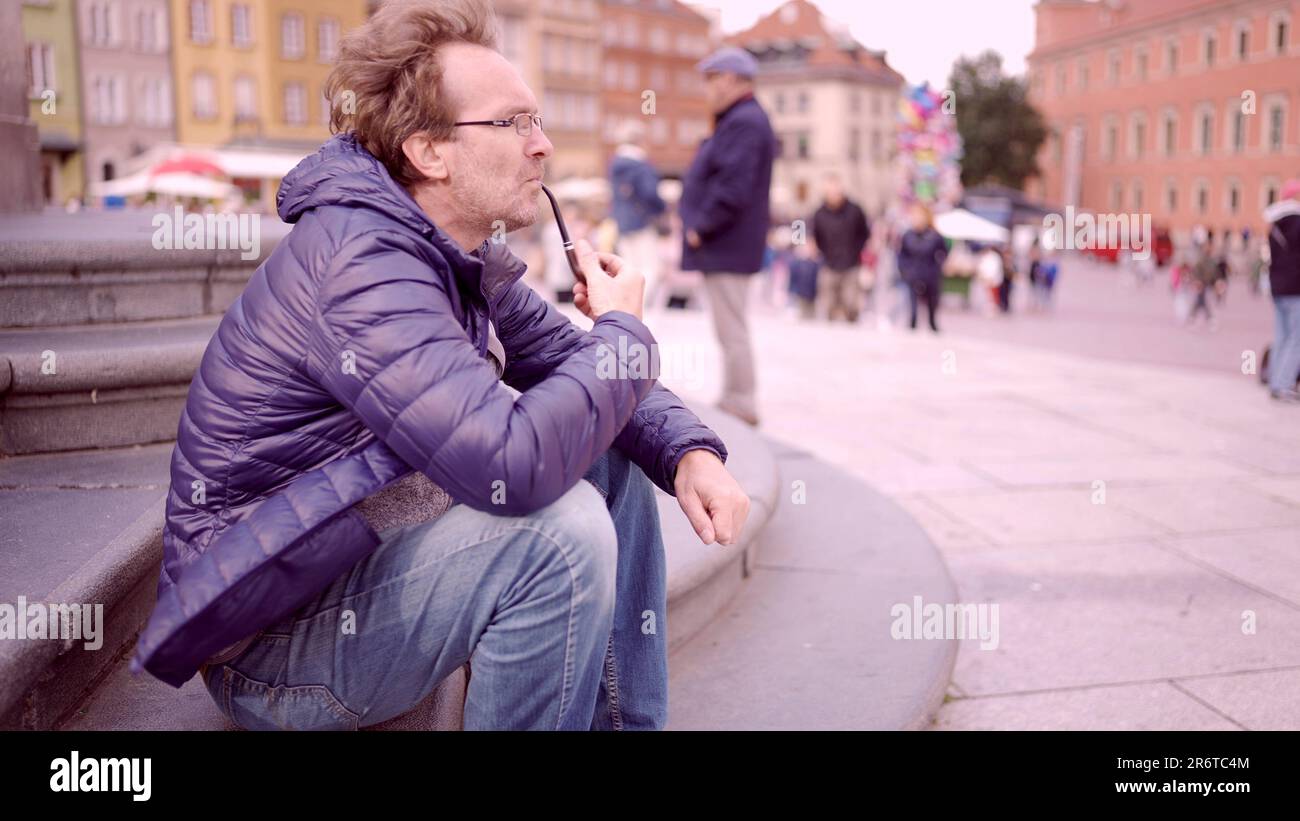 Adult man sitting on square and smoking a tobacco pipe in the Palace ...