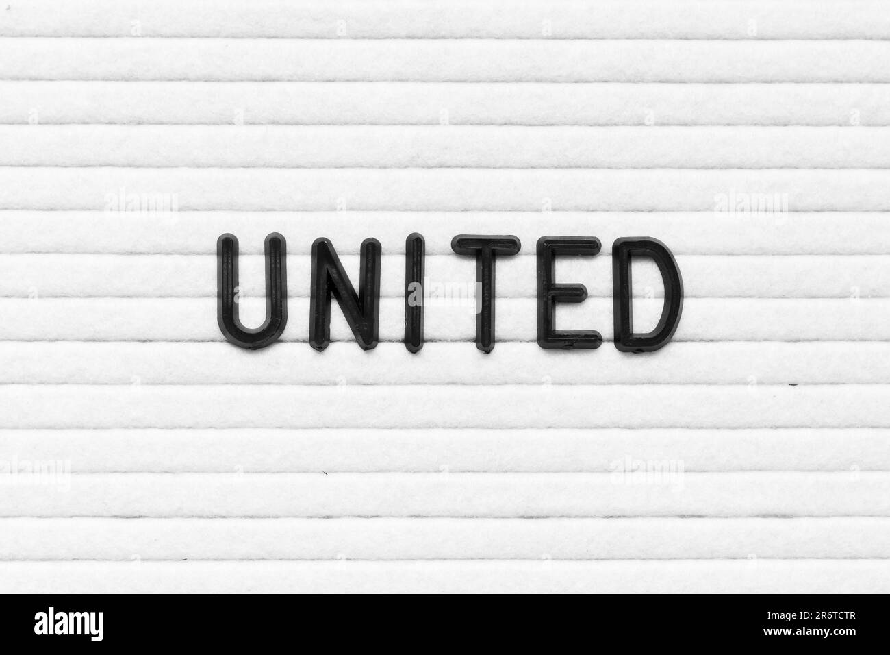 Black color letter in word united uon white felt board background Stock ...