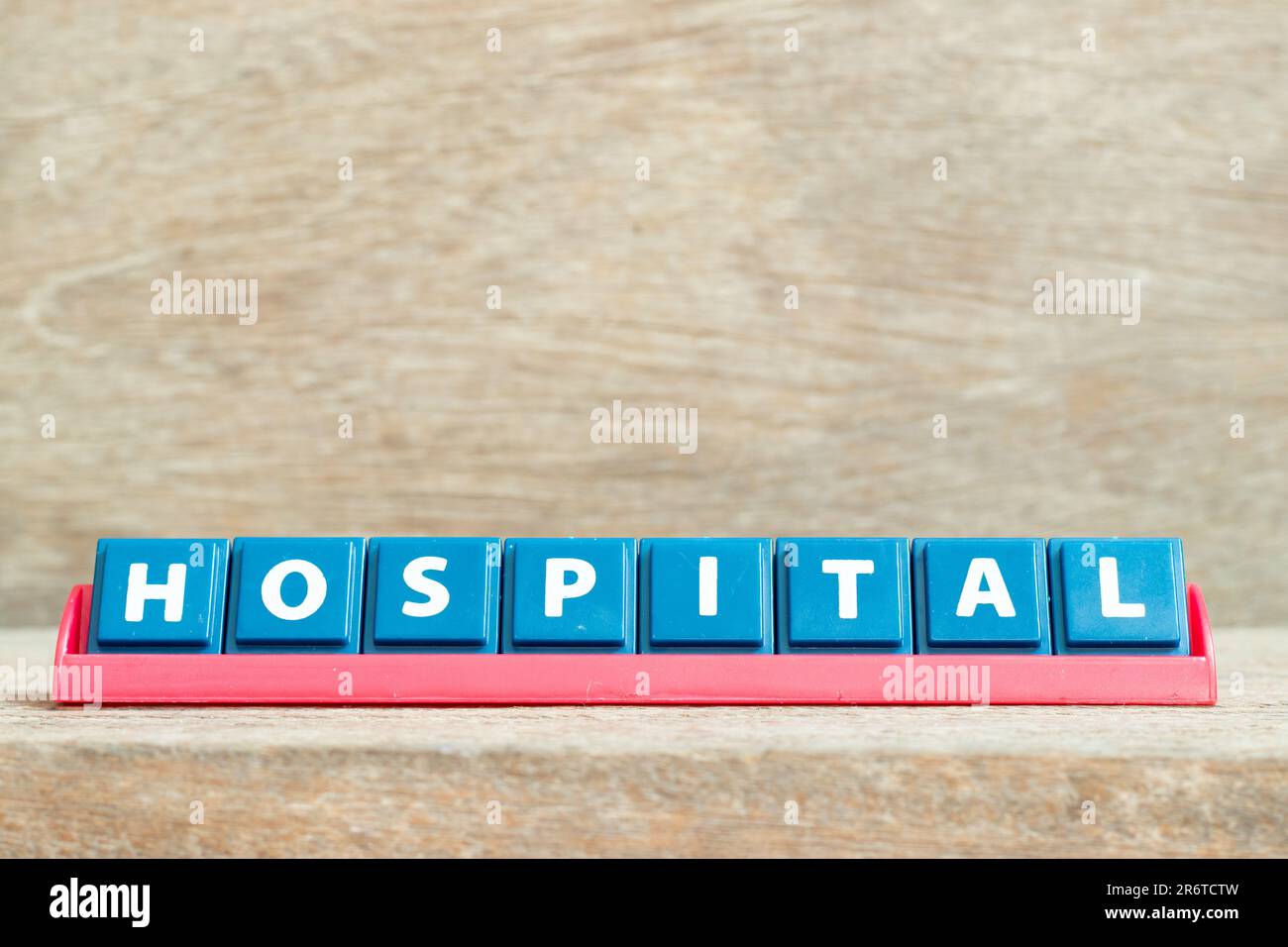 Tile alphabet letter with word hospital in red color rack on wood ...