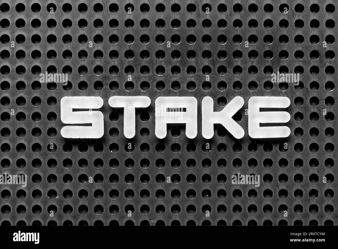 White alphabet letter in word stake on black pegboard background Stock ...