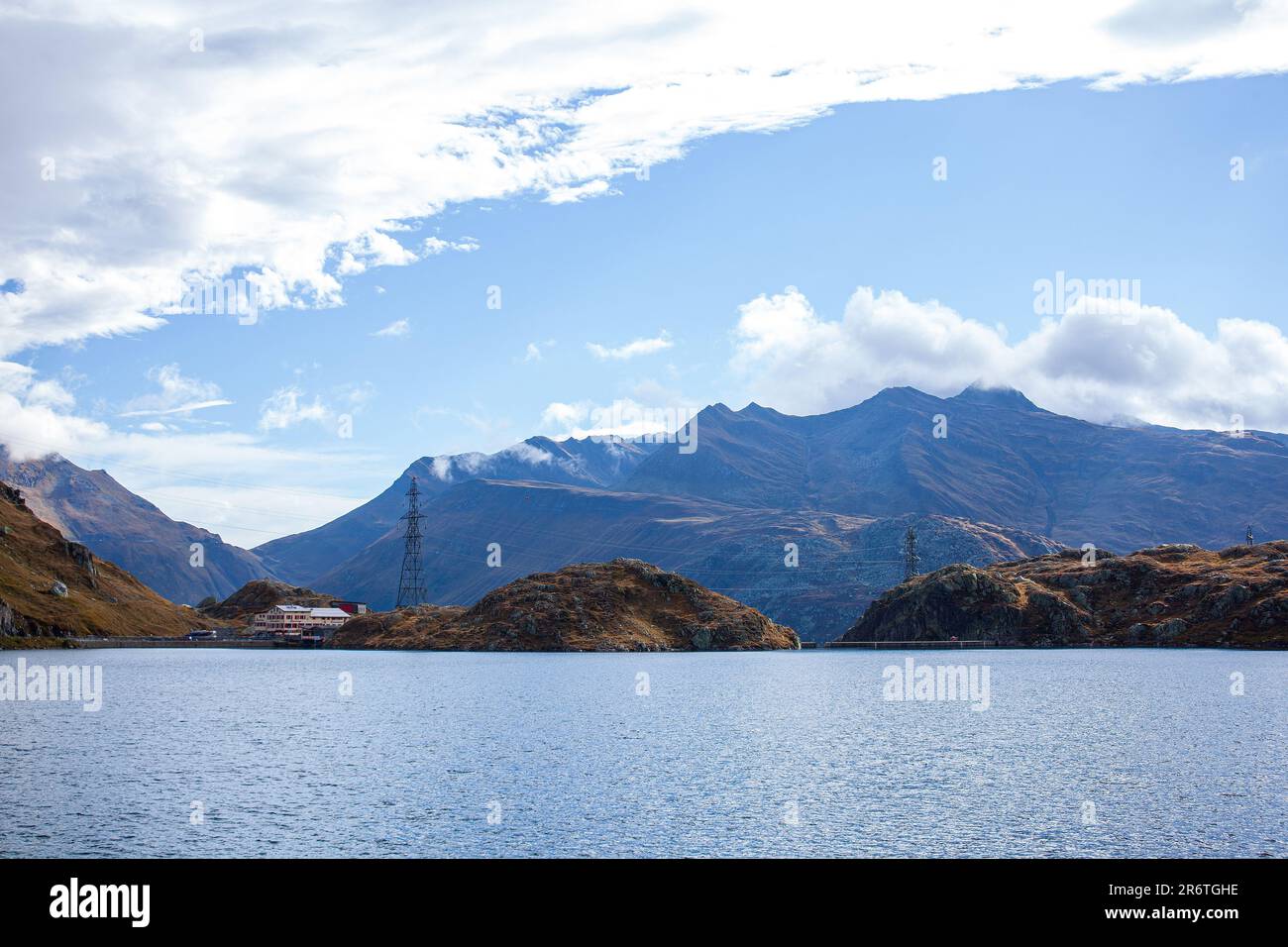 High mountain lake in Switzerland with towering power line towers ...