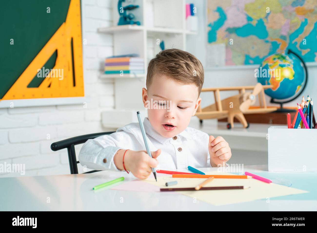 Kid boy writing in classroom. Child of primary school Stock Photo - Alamy