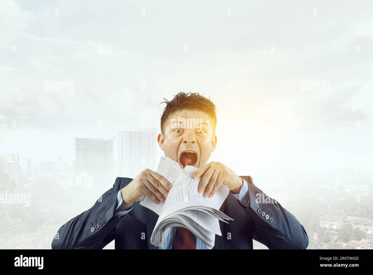 Young stressed man ripping documents with frustrated facial expression ...
