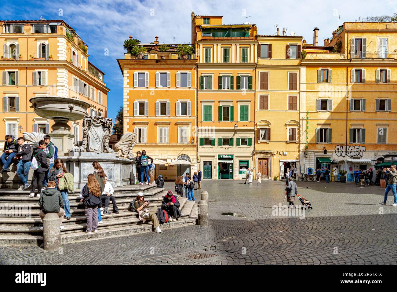 People sitting around the Fontana di Santa Maria,a fountain in the ...