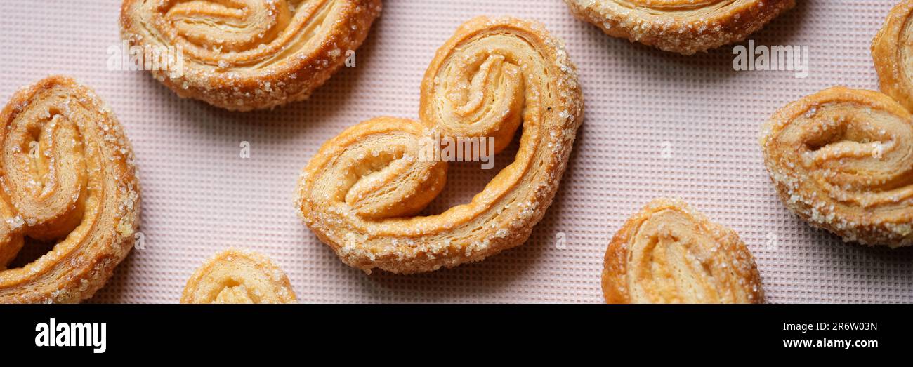 Tasty puff pastry cookies with sugar sprinkle on pink background Stock ...