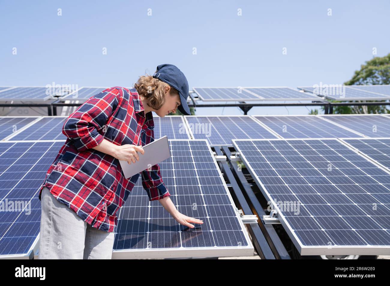Woman with digital tablet touching solar panel Stock Photo - Alamy
