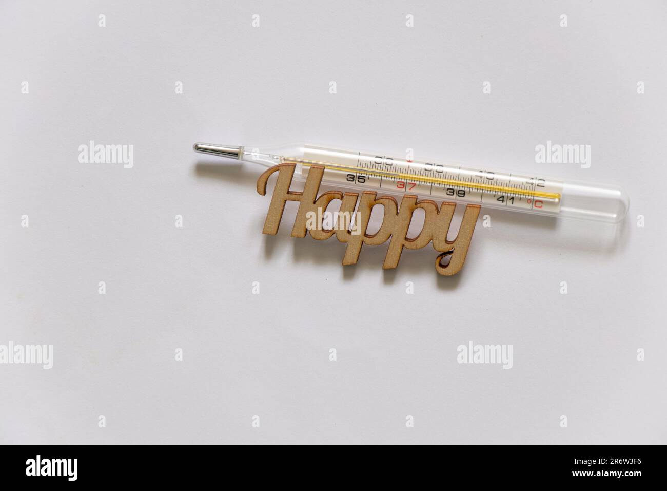 glass thermometer and the word happiness made of wood on a white Stock ...