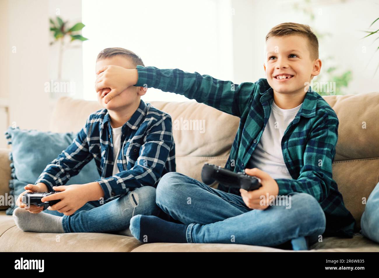 child brother friend having fun playing console laughing happy kid ...