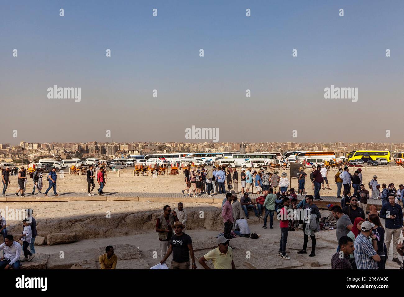 Tourists arriving by coach at Giza Plateau to visit the pyramids, with ...