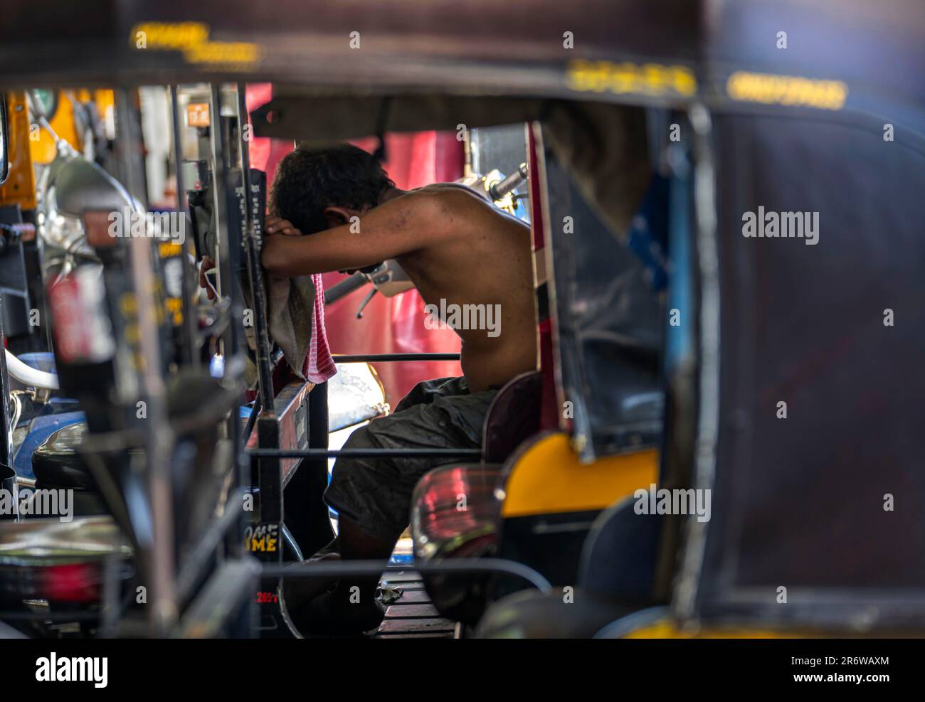 A driver takes a nap on a hot afternoon in his auto-rickshaw in Mumbai, India, Sunday, June 11 ...