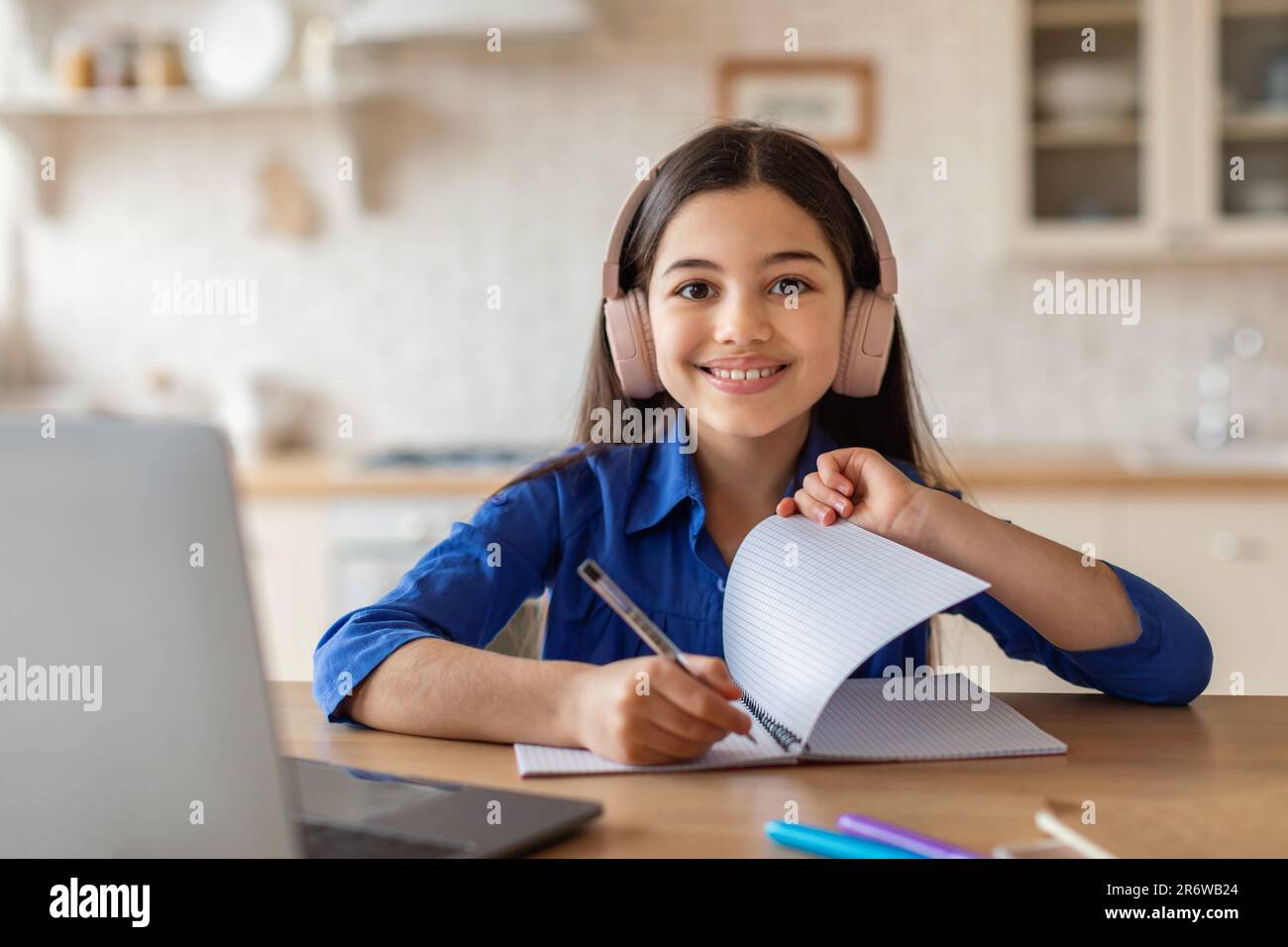Happy Girl Writing In Textbook Studying At Laptop At Home Stock Photo ...