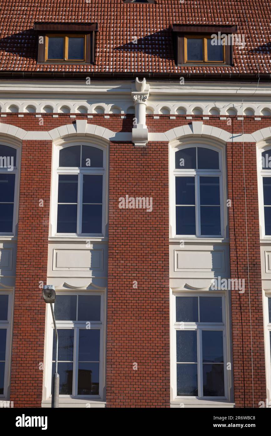 The facade of a historic building built of red brick in the neo-Gothic ...