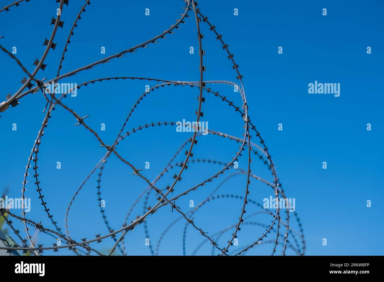 Barbed wire on blue sky background. Concept of boundary, prison, war or ...