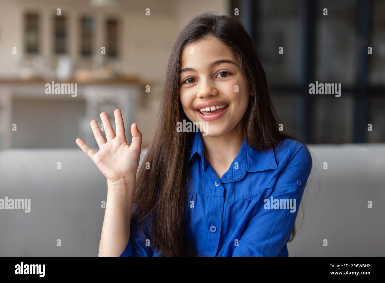 Arabic Kid Girl Waving Hand Gesturing Hi Sitting At Home Stock Photo ...