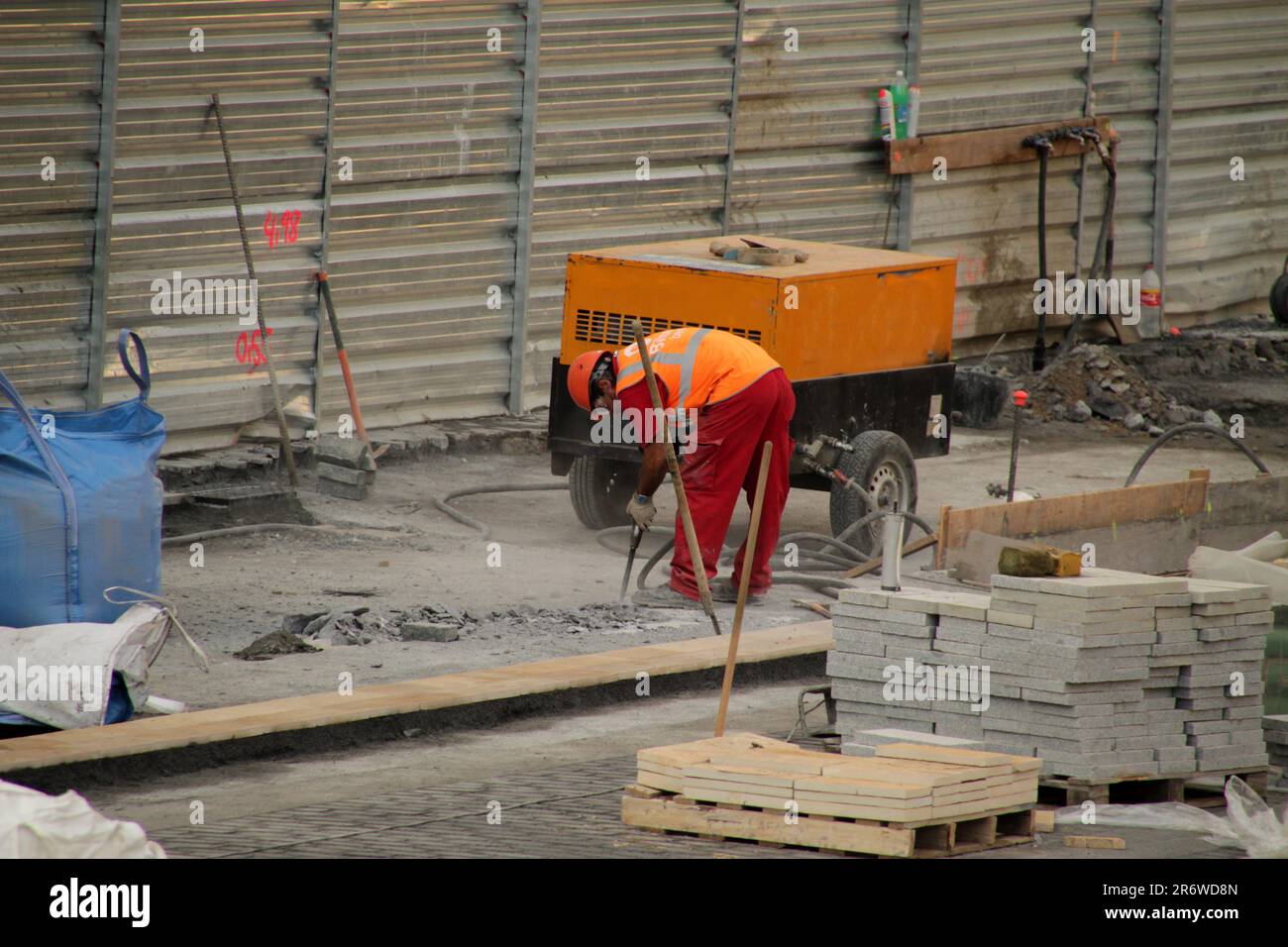 A diverse group of workers stand at a construction site, surrounded by ...