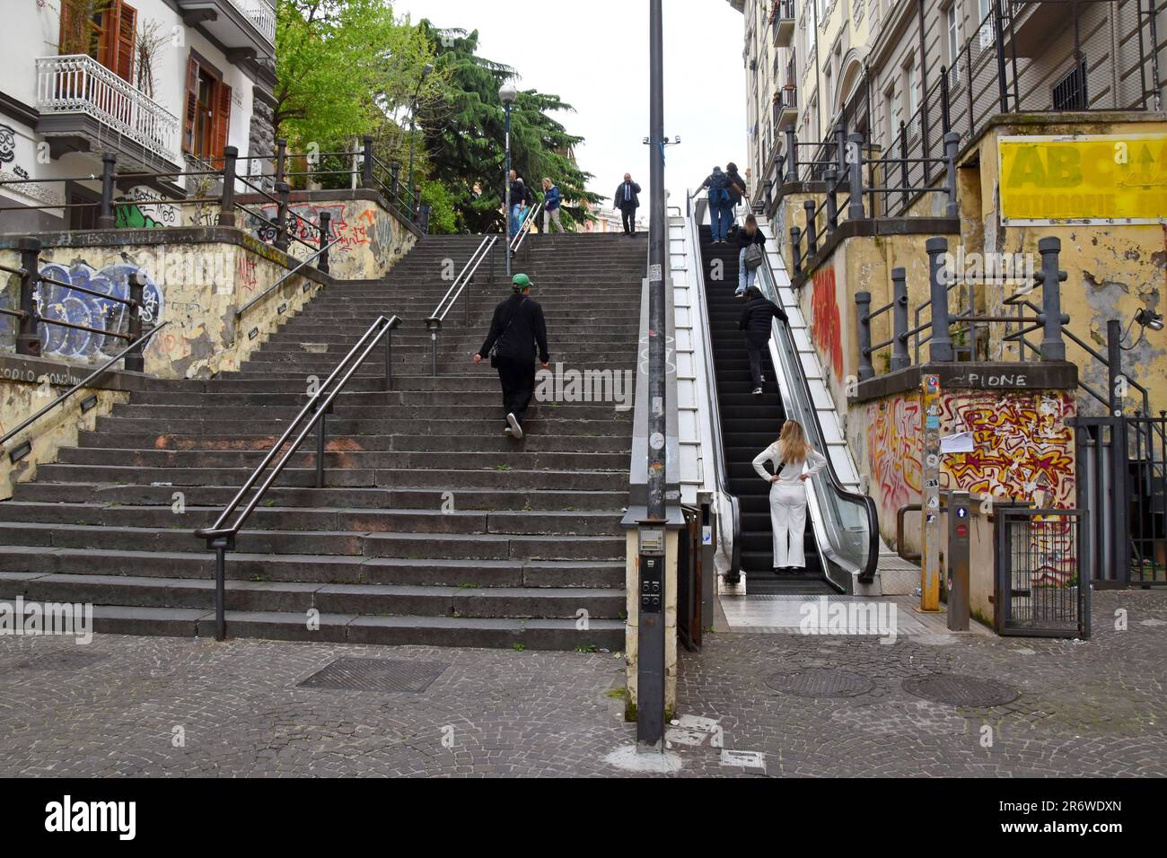 An outdoor public escalator next to steps in a street in Naples, Italy ...