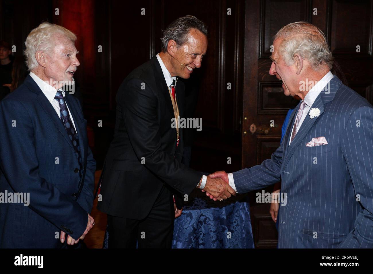 King Charles III greets Derek Jacobi (left) and Richard E. Grant, during a reception with ...