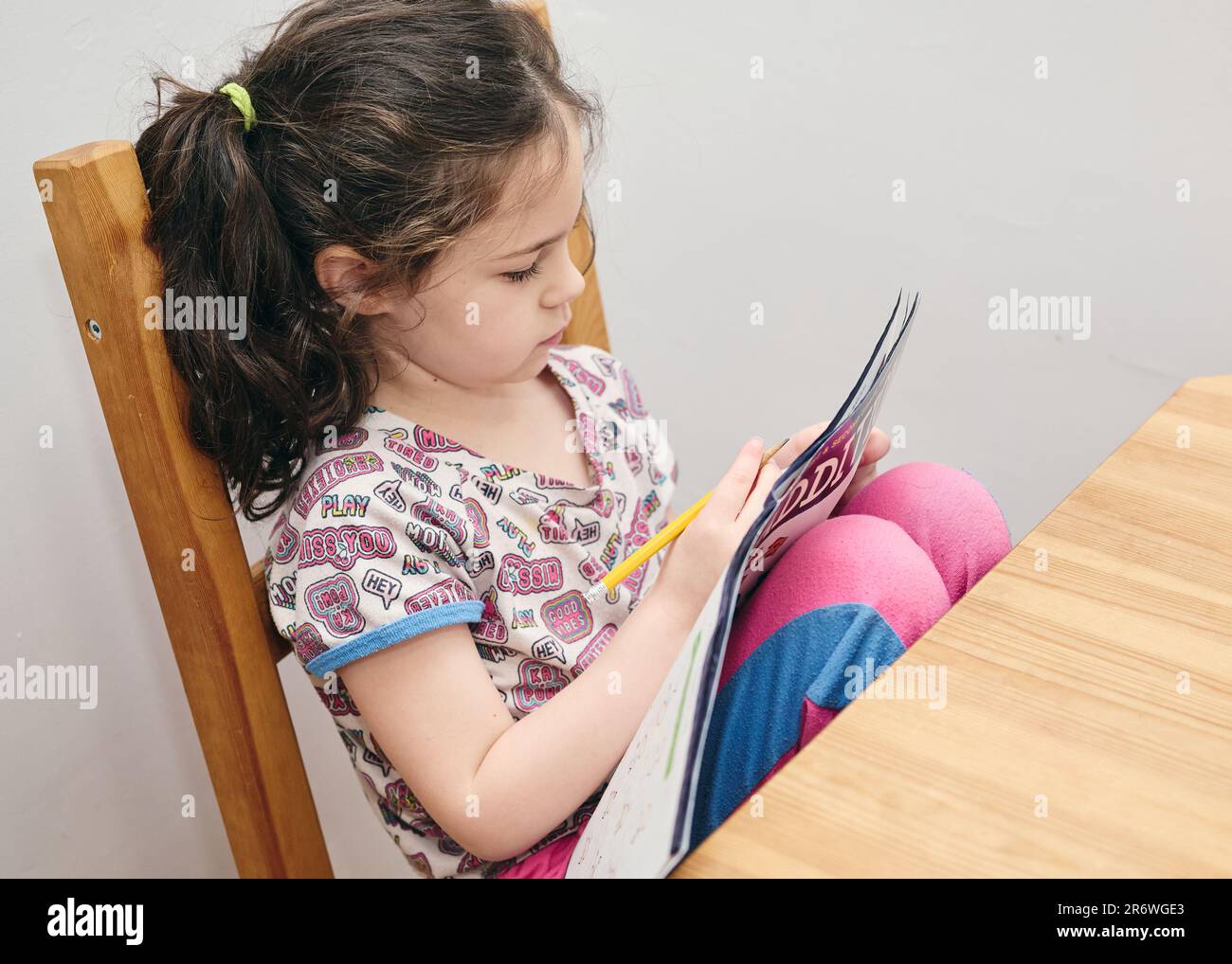 cute girl solving math puzzles at the kitchen table Stock Photo - Alamy