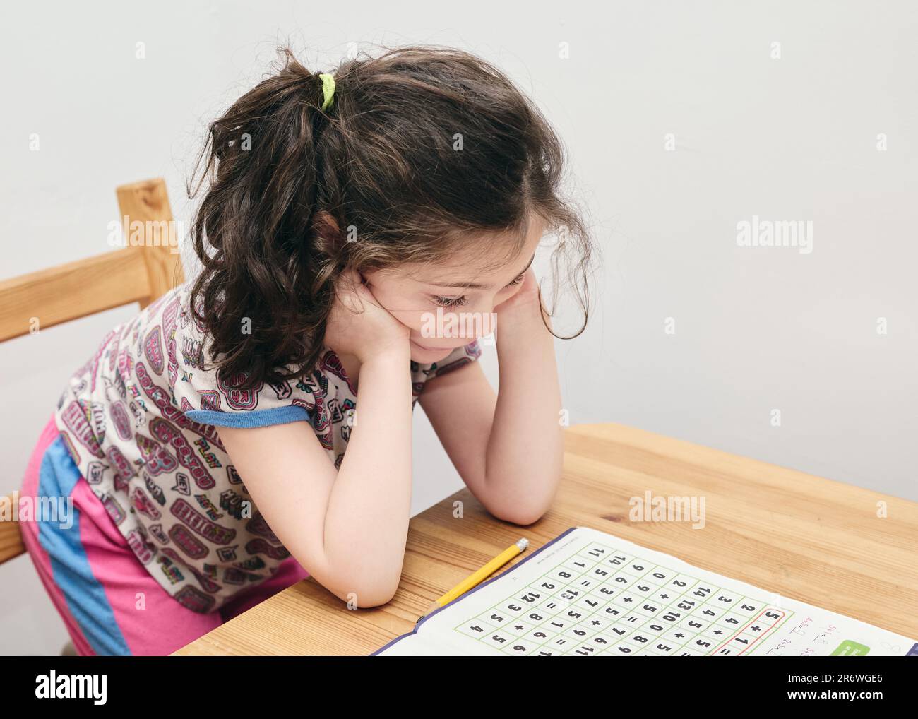 cute girl solving math puzzles at the kitchen table Stock Photo - Alamy