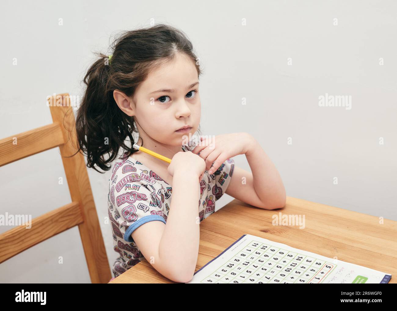 cute girl solving math puzzles at the kitchen table Stock Photo - Alamy