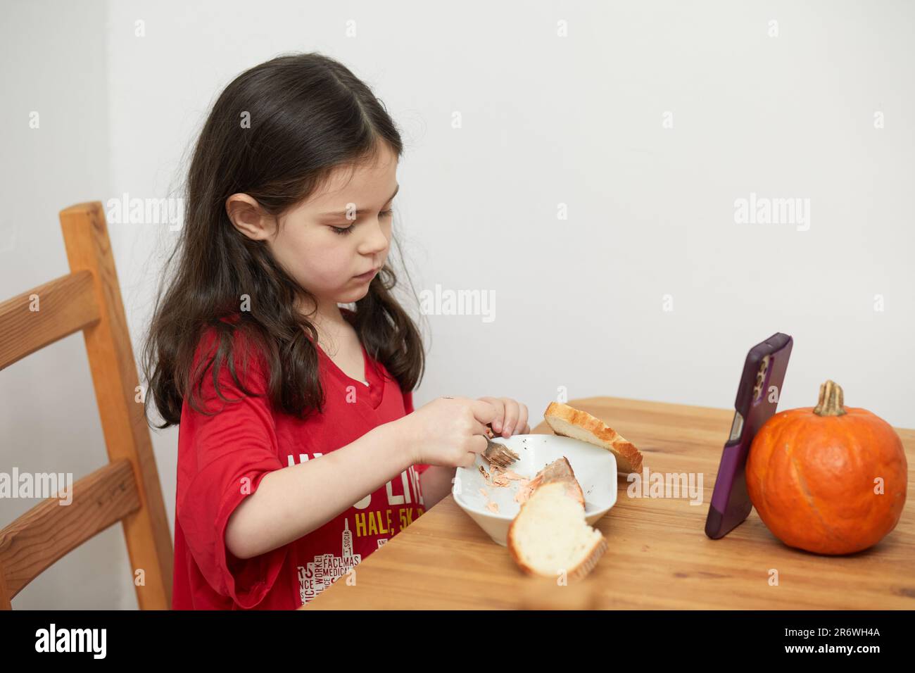 cute young girl with a missing primary tooth is talking while eating a ...