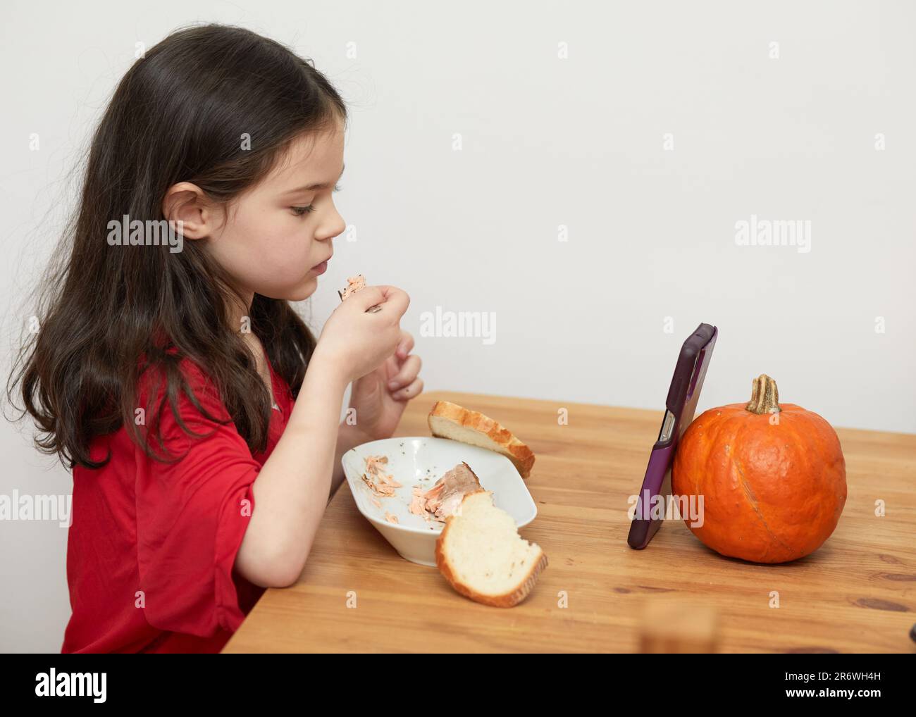 cute young girl with a missing primary tooth is talking while eating a ...