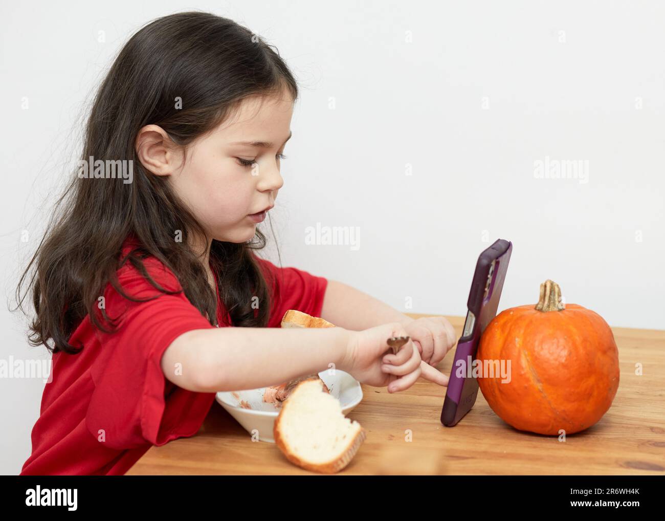 cute young girl with a missing primary tooth is talking while eating a ...