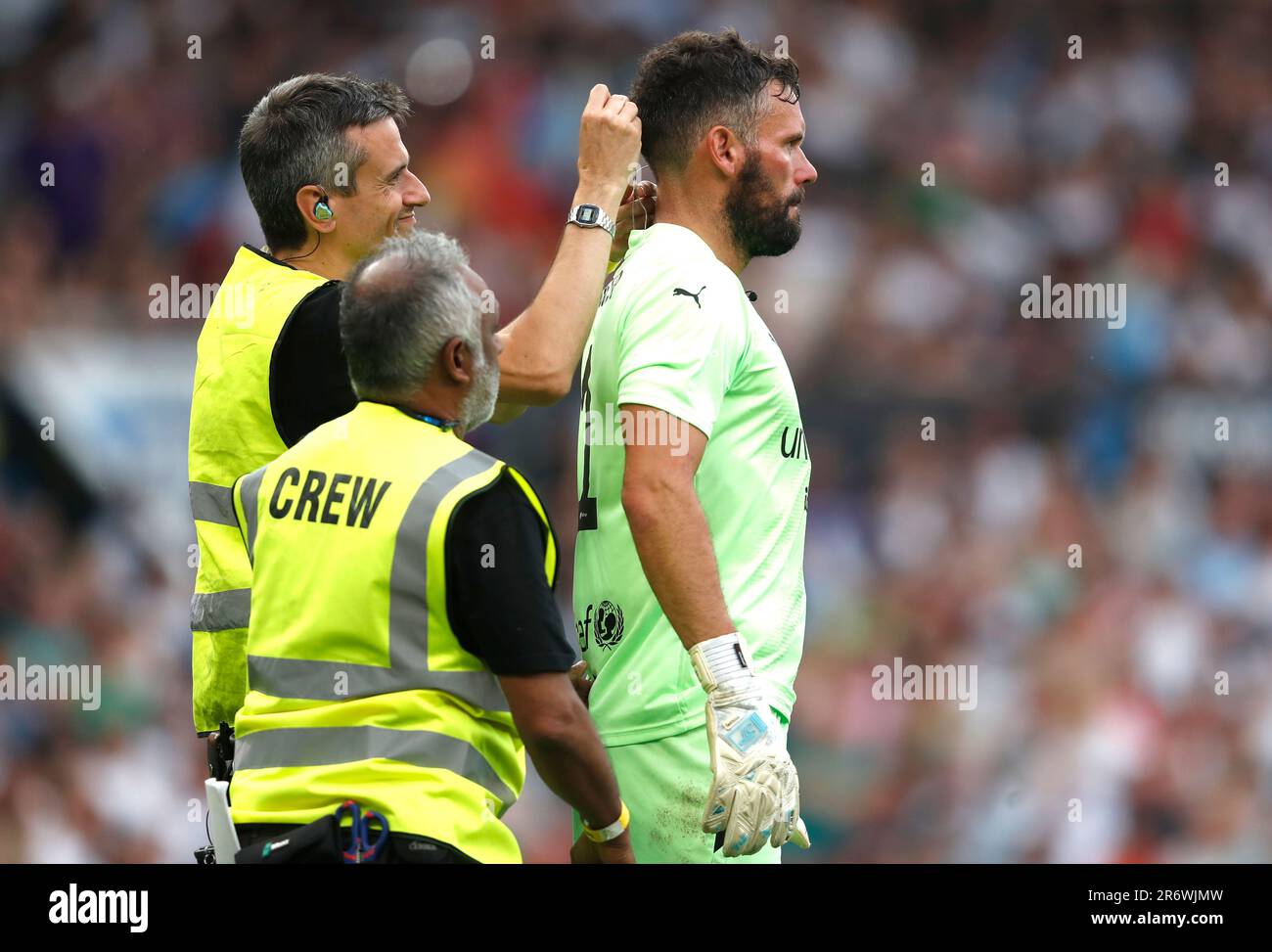 Crew members fix the mic that Soccer Aid World XI goalkeeper Ben Foster ...